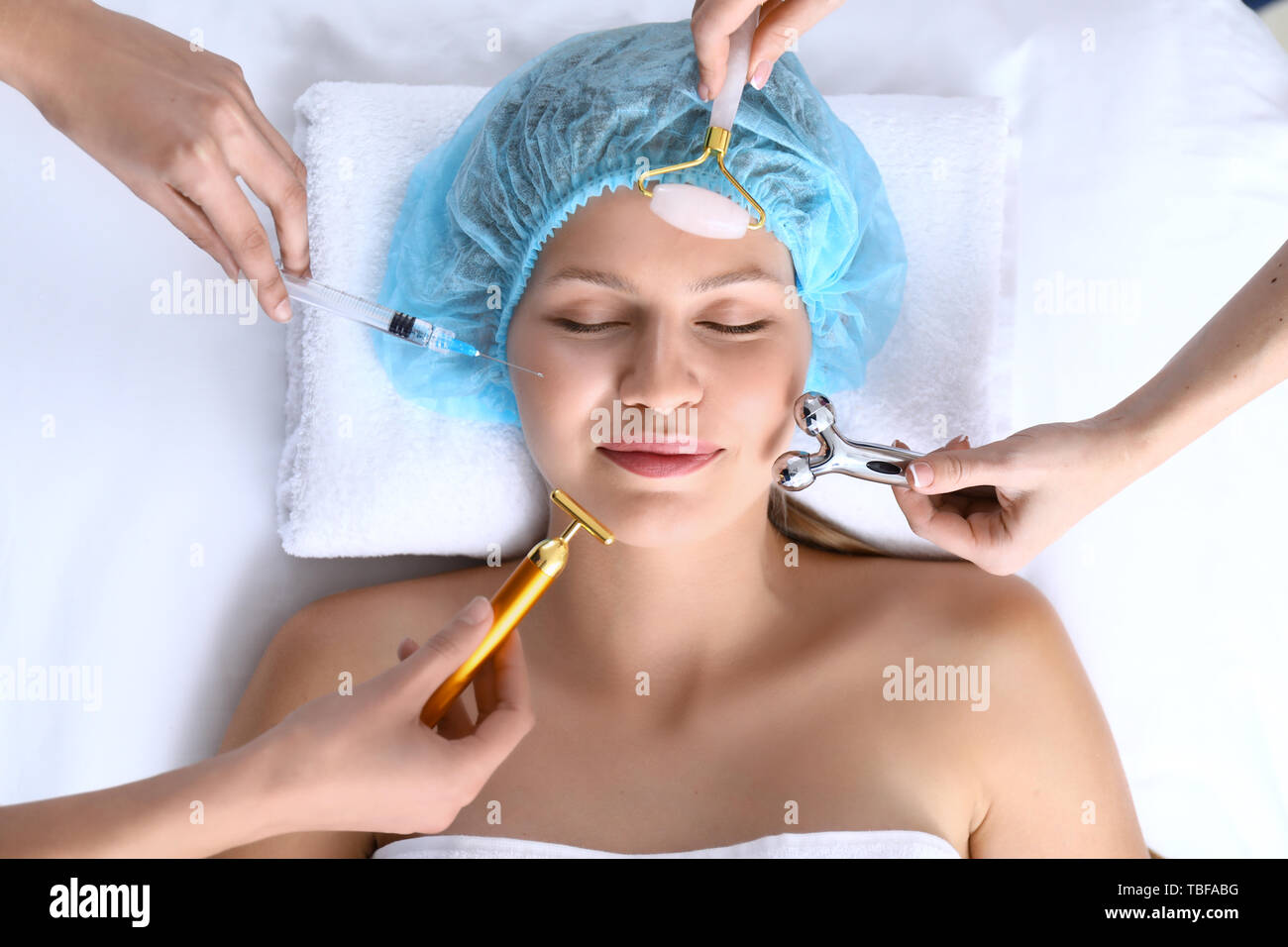 Young woman with different cosmetic devices in beauty salon Stock Photo ...