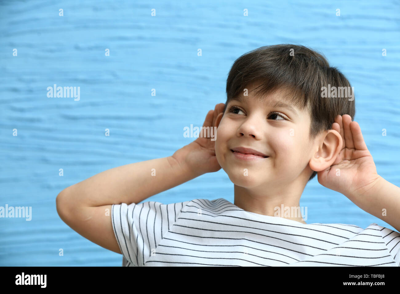 Little boy with hearing problem on color background Stock Photo - Alamy