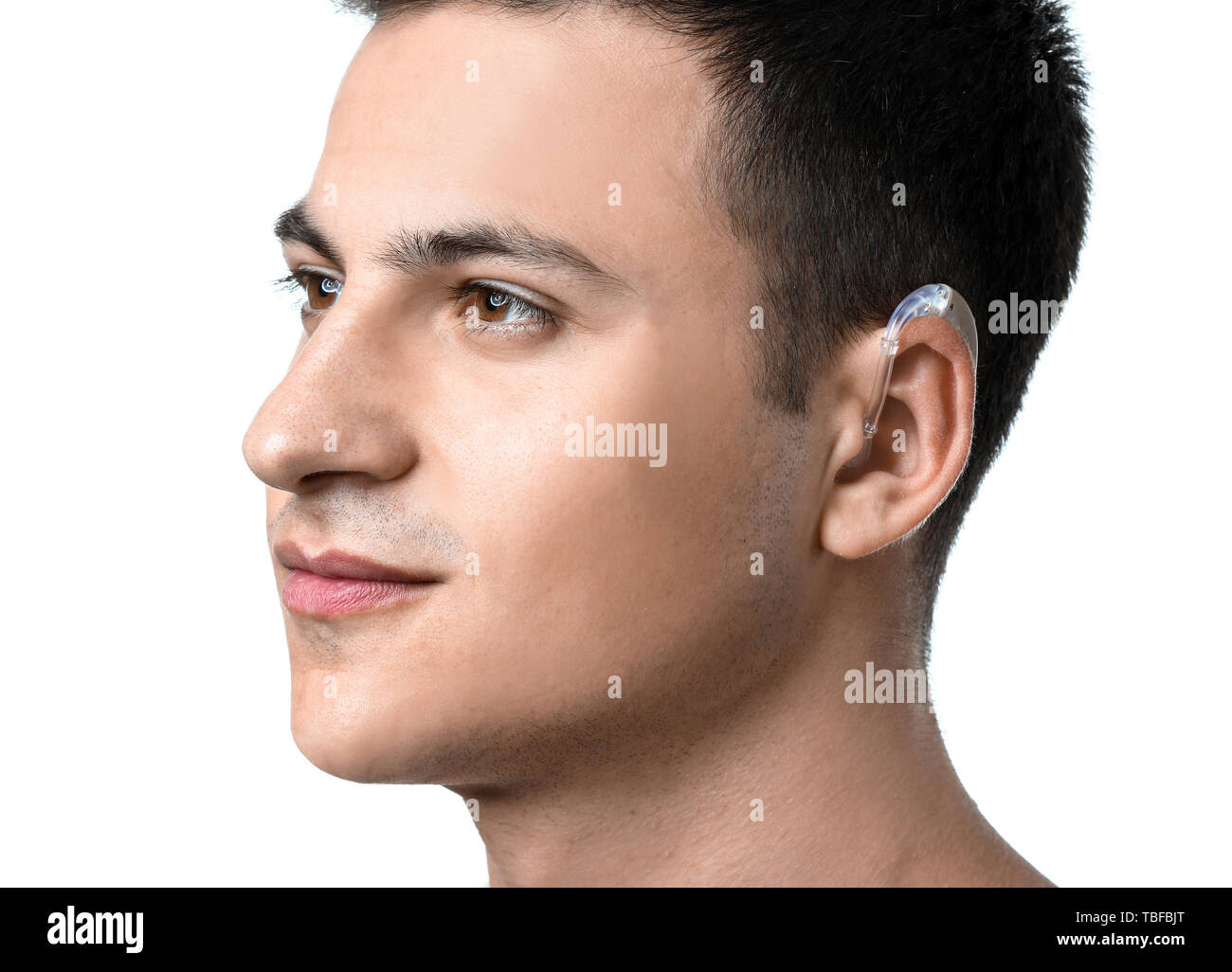 Young man with hearing aid on white background Stock Photo - Alamy