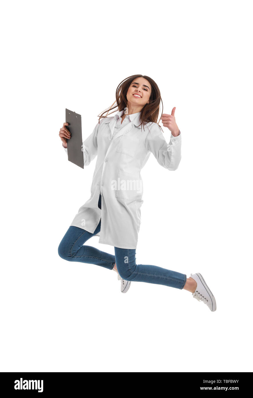 Happy female doctor jumping against white background Stock Photo - Alamy