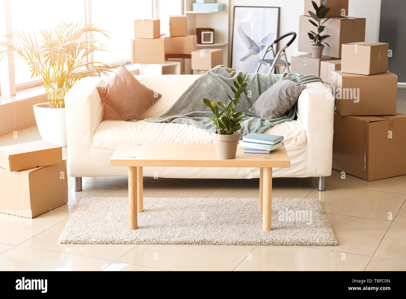Furniture, belongings and moving boxes in room Stock Photo - Alamy