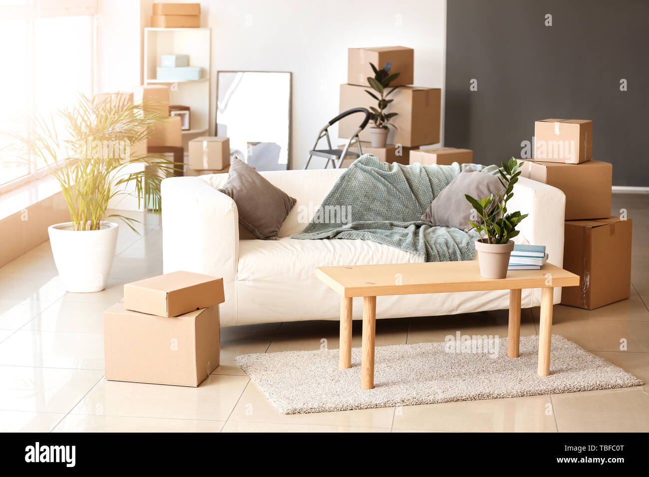 Furniture, belongings and moving boxes in room Stock Photo - Alamy