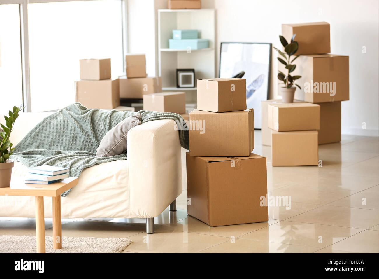 Furniture, belongings and moving boxes in room Stock Photo - Alamy