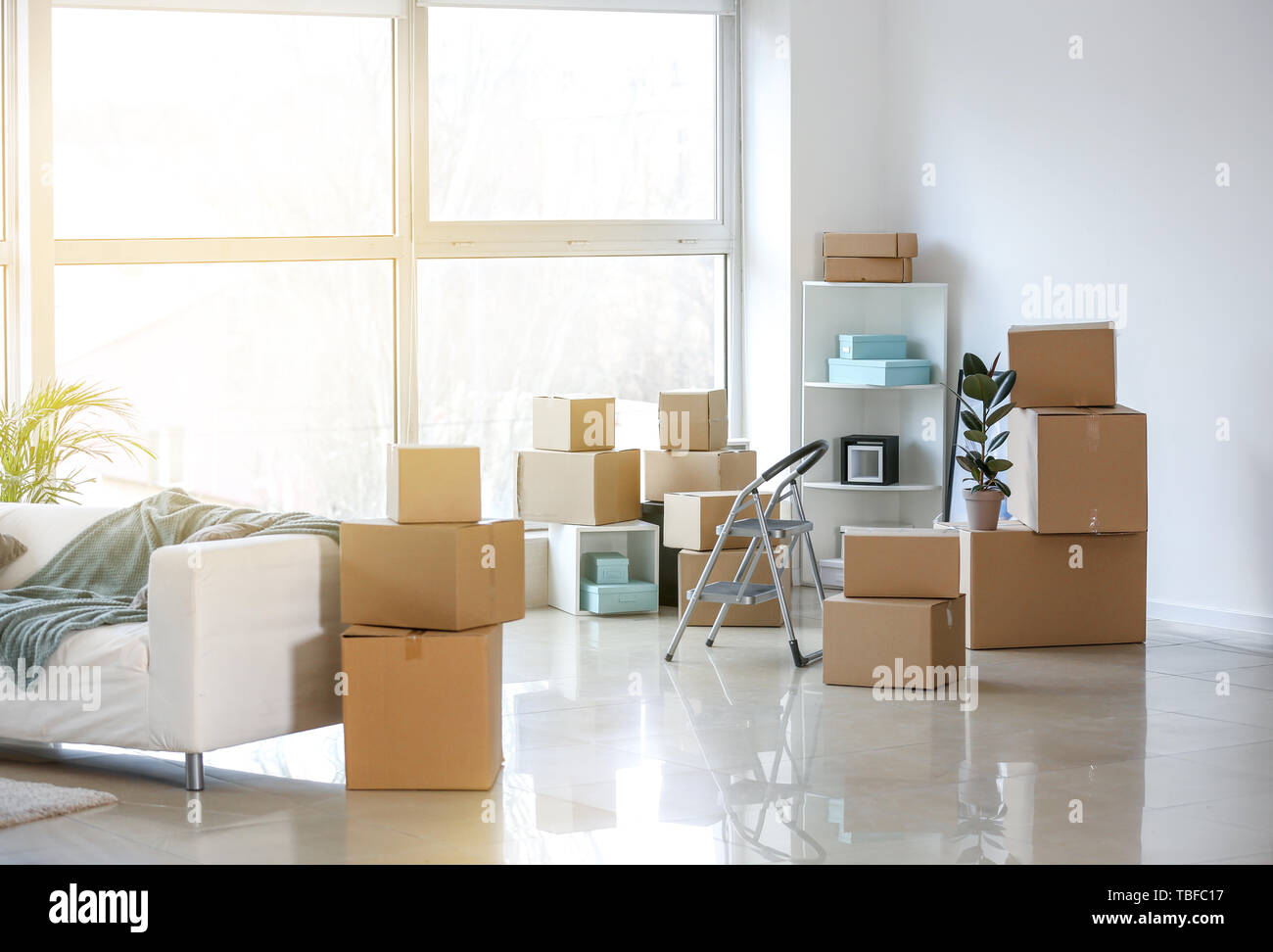 Furniture, belongings and moving boxes in room Stock Photo - Alamy