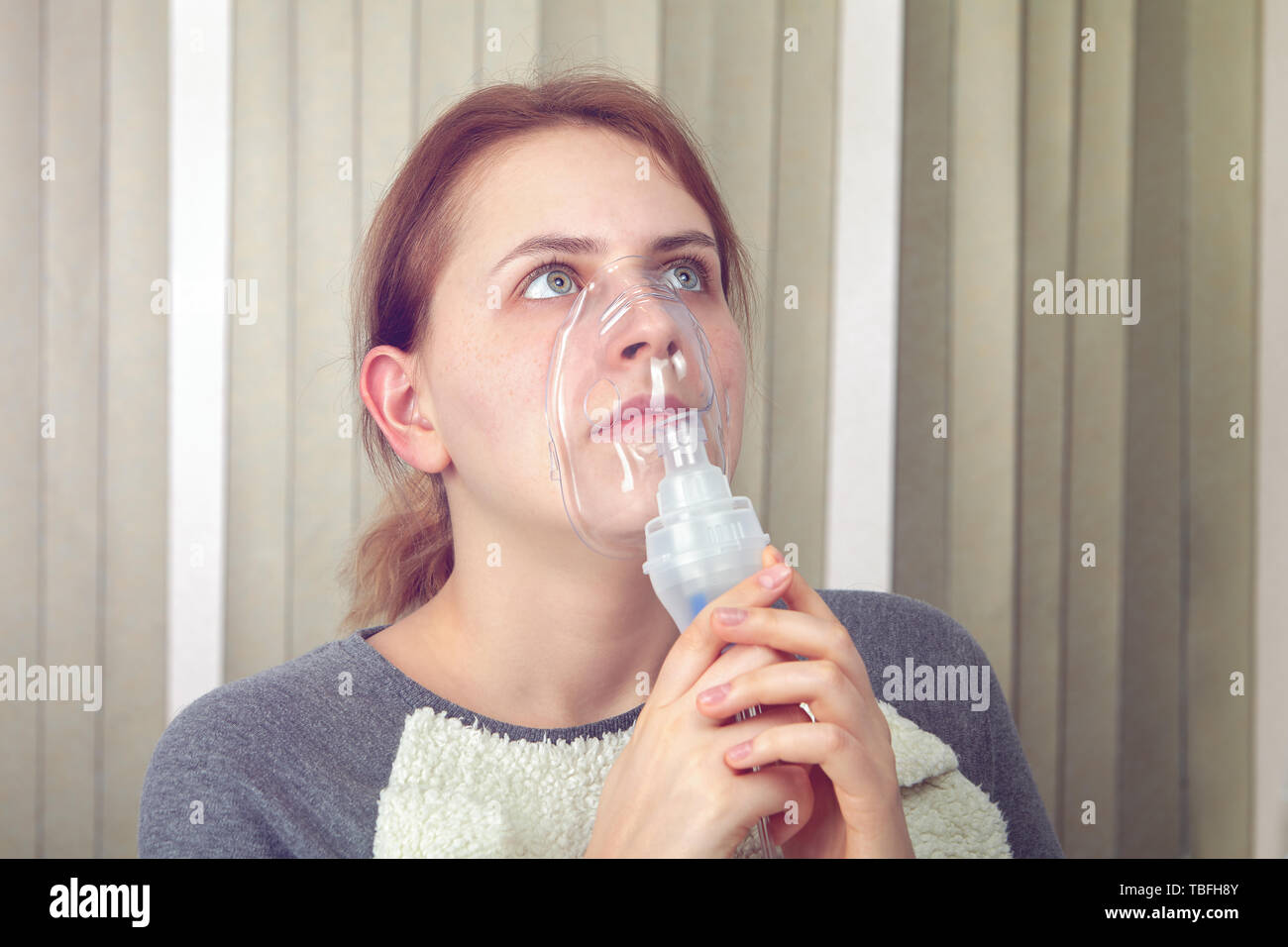 Woman Is Making Inhalation With Nebulizer Chamber To Stop Asthma Attack woman-is-making-inhalation-with-nebulizer-chamber-to-stop-asthma-attack