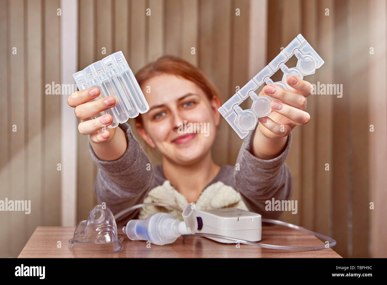 Young woman, who has breathing issues, is preparing compressor ...