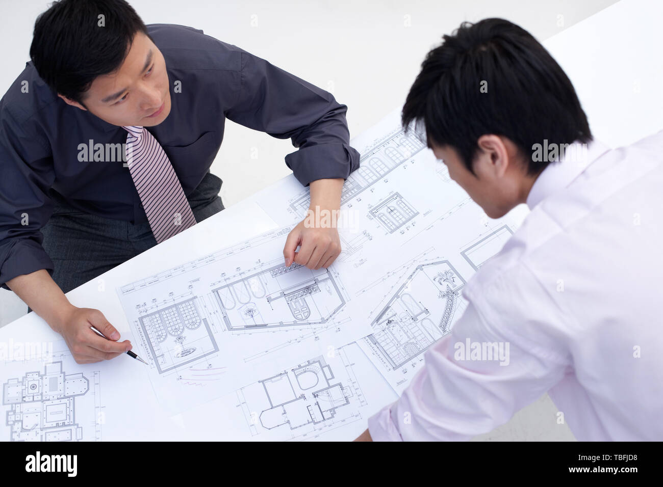 Business people analyzing drawings Stock Photo - Alamy