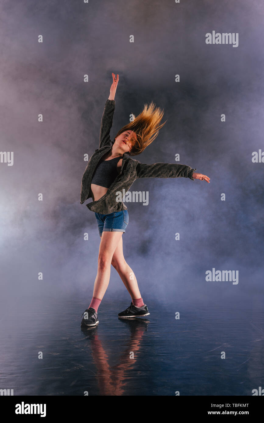 Female dancer shows off her elegance by moving her back leg high over ...