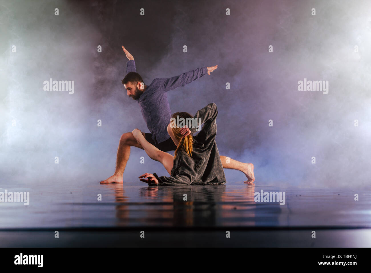 Shoeless dance couple performing multiple unique dance moves in front ...