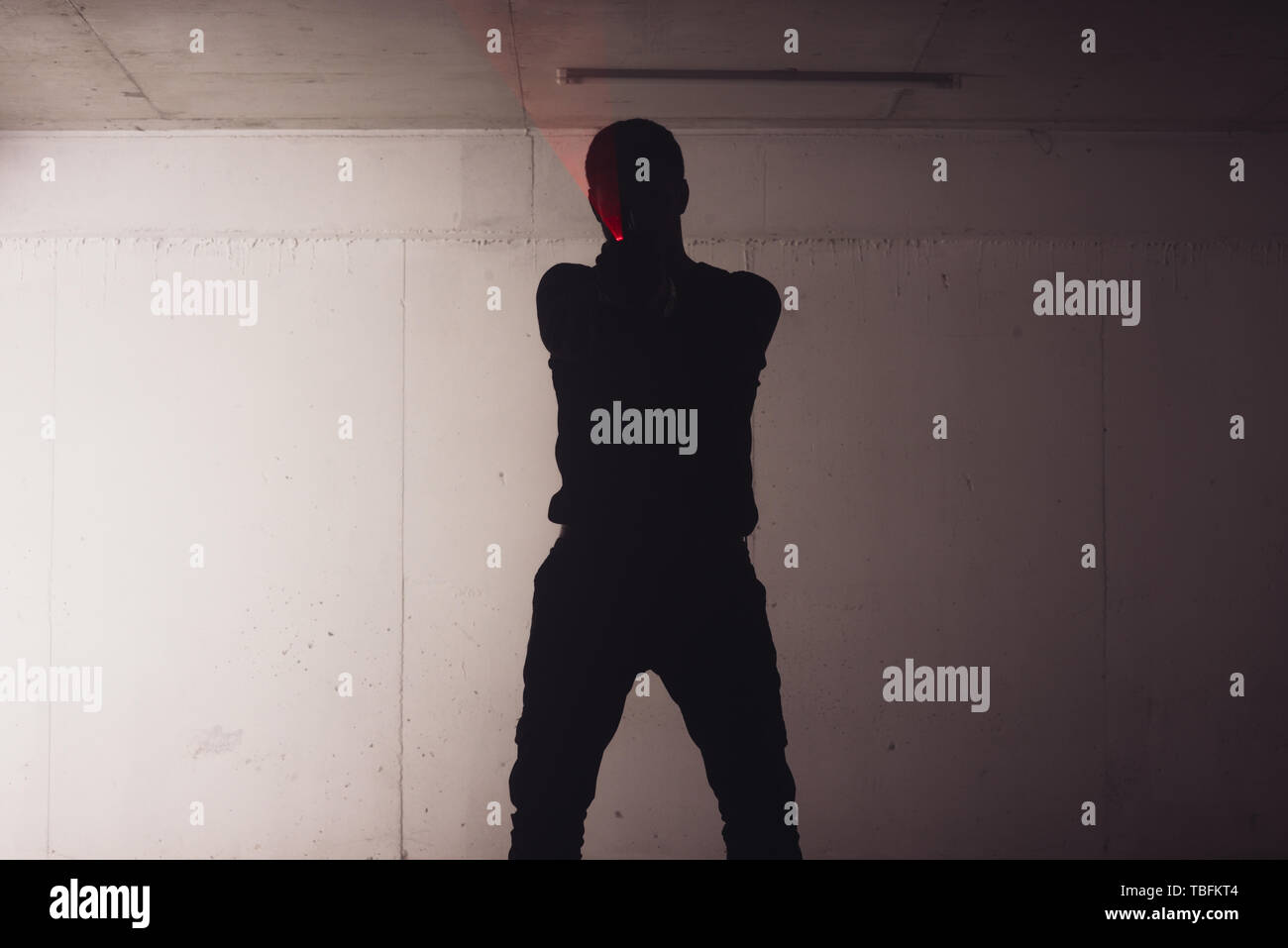 silhouette of an armed man holding his gun and pointing with his laser ...