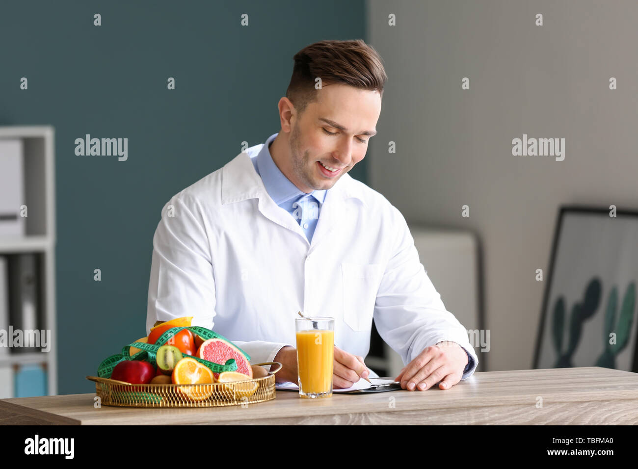 Male nutritionist working in his office Stock Photo - Alamy