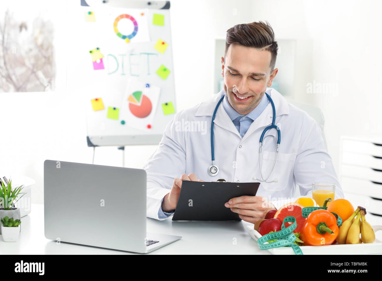 Male nutritionist working in his office Stock Photo - Alamy