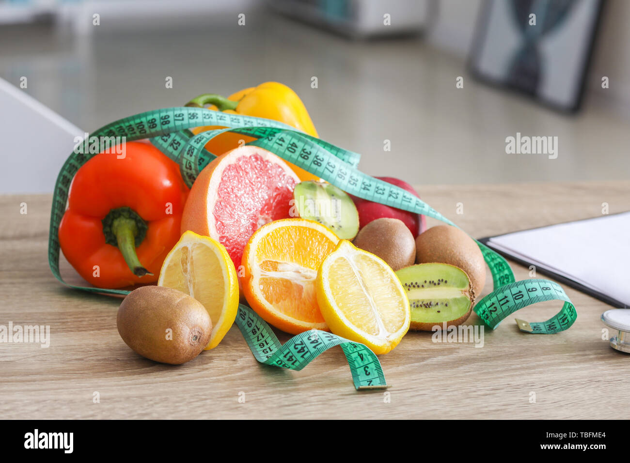 Fresh fruits and vegetables with measuring tape on table of ...