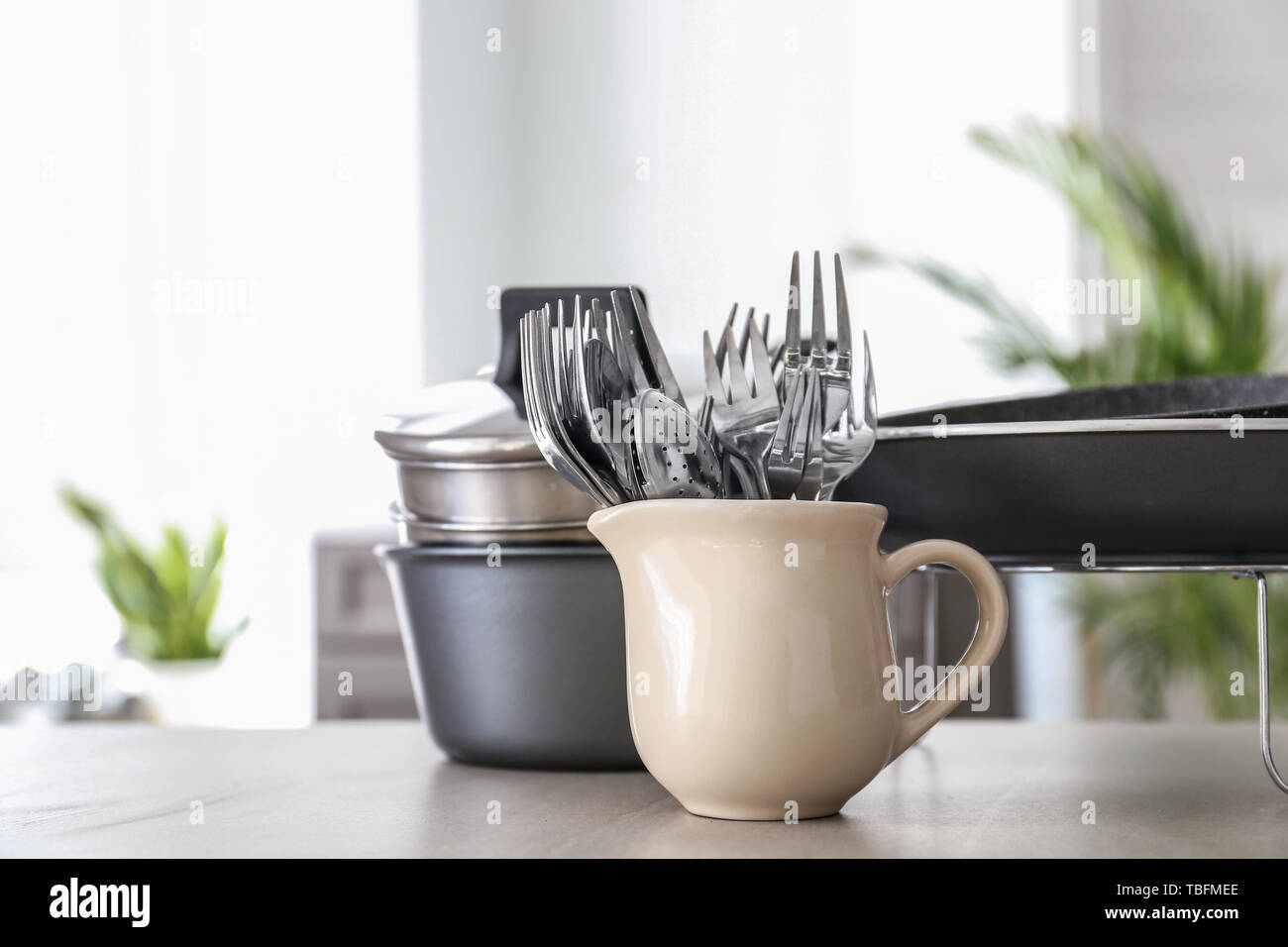 Set of utensils with cutlery on table in kitchen Stock Photo - Alamy