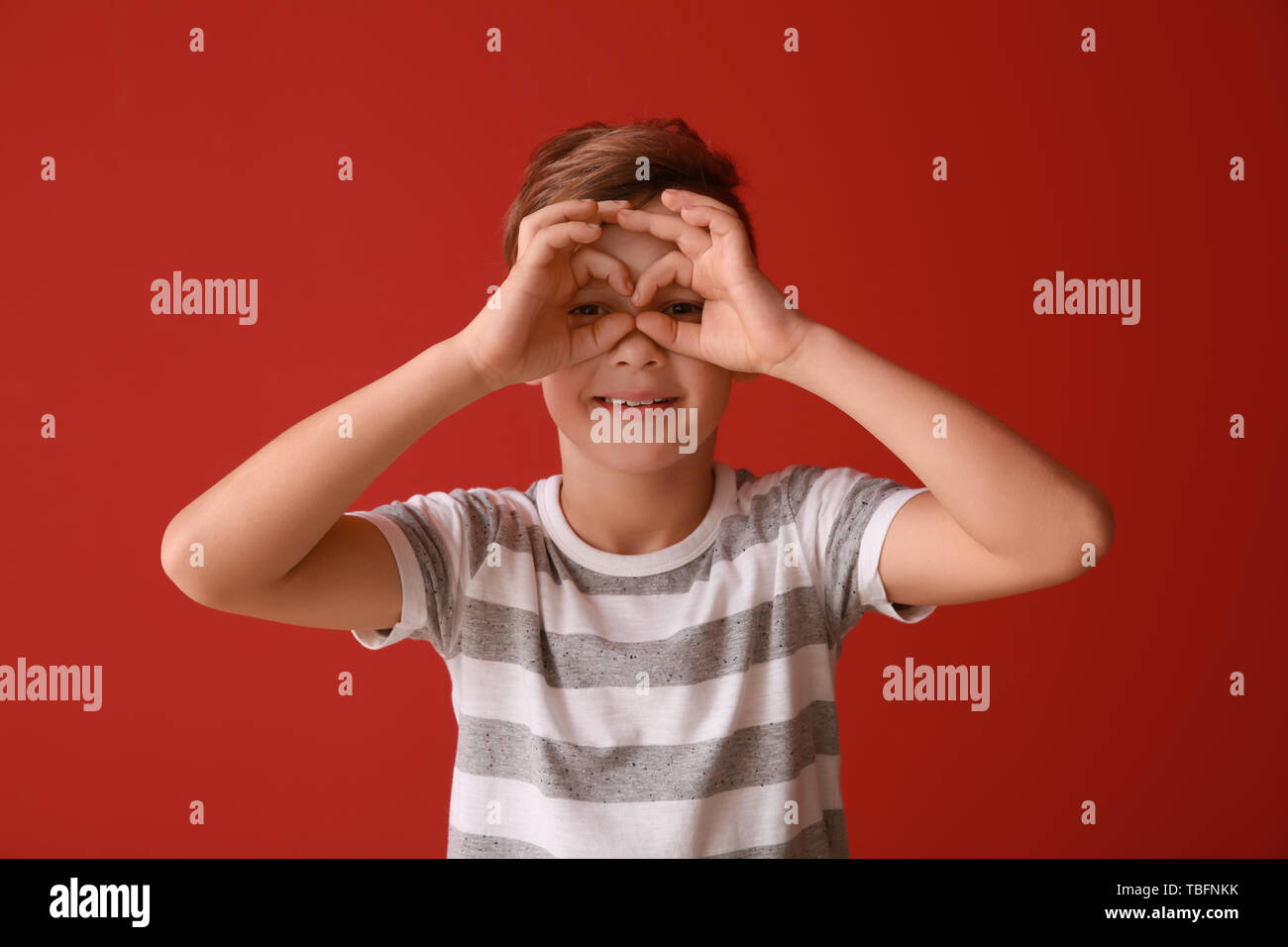 Funny grimacing little boy on color background Stock Photo - Alamy