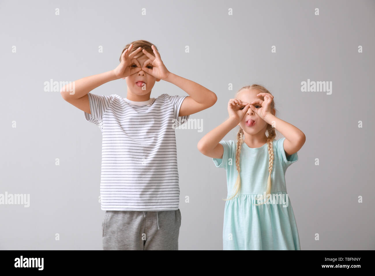 Funny grimacing little children on light background Stock Photo - Alamy