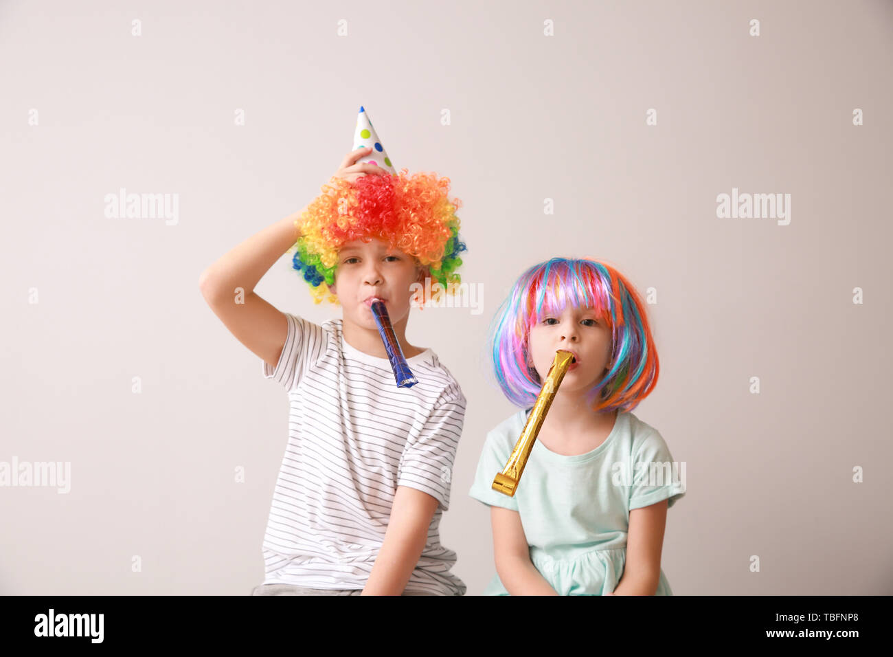 Little children in funny disguise on light background. April fools' day ...
