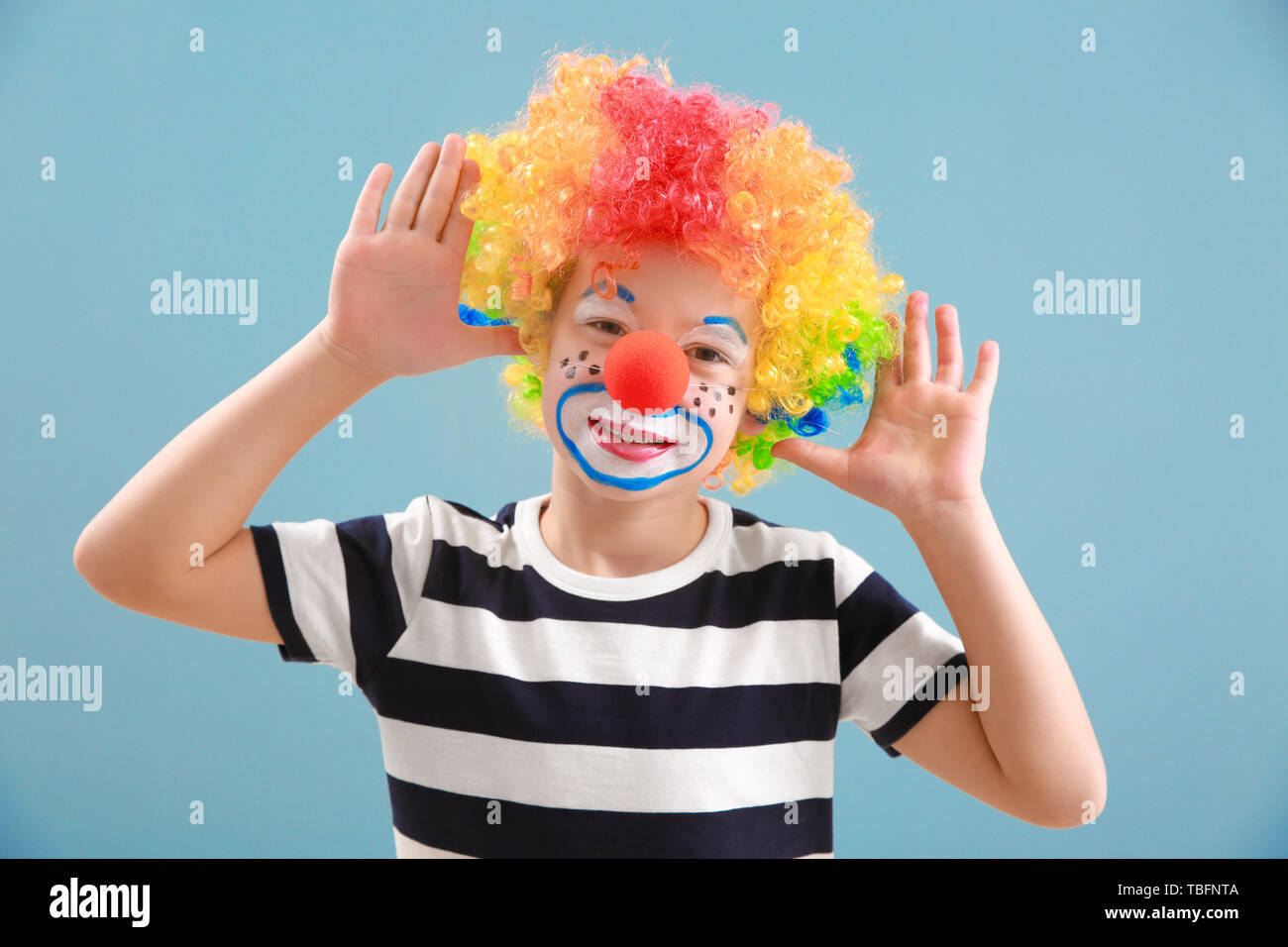 Cute little boy with clown makeup on color background. April fools' day ...