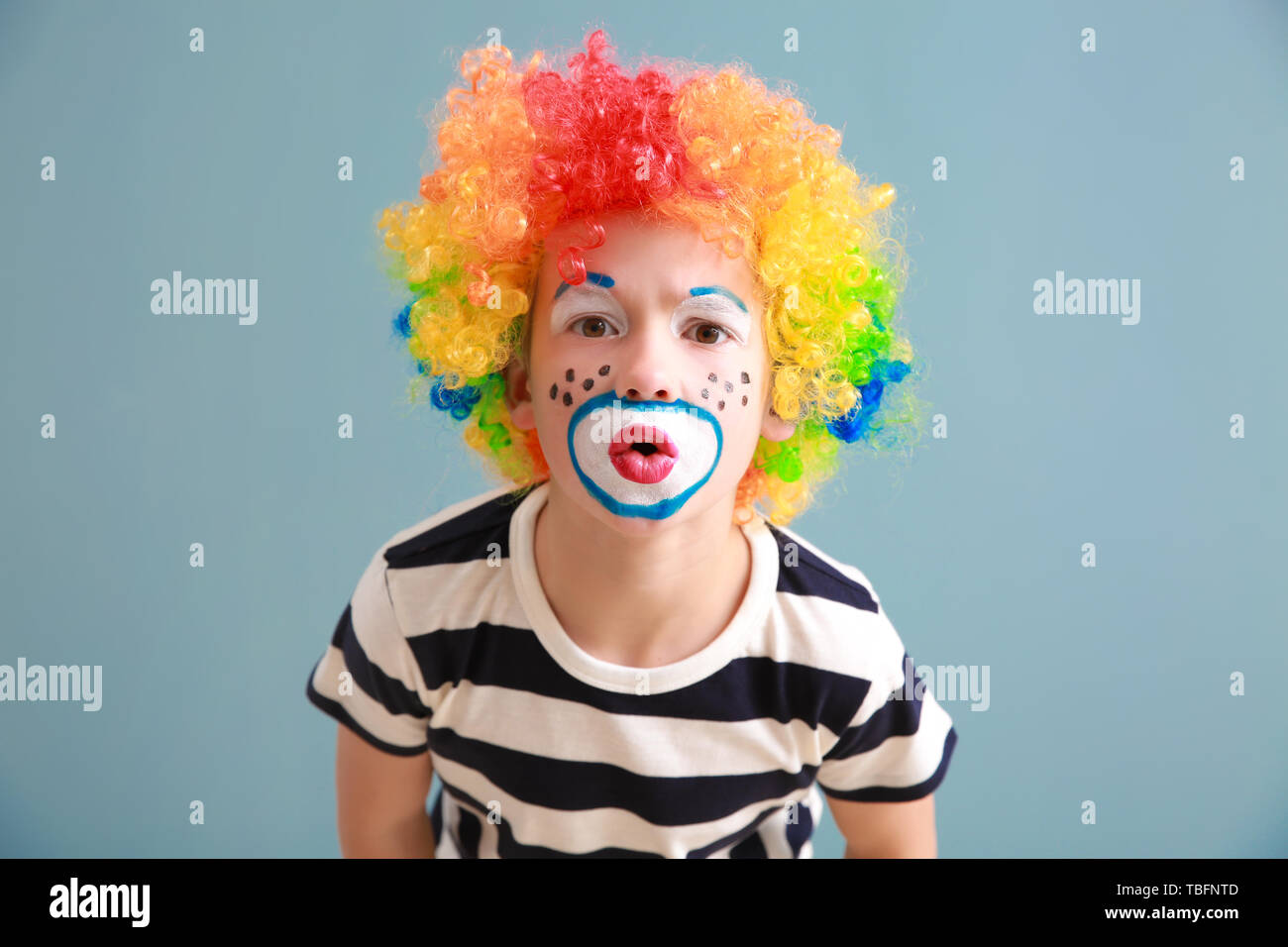 Cute little boy with clown makeup on color background. April fools' day ...
