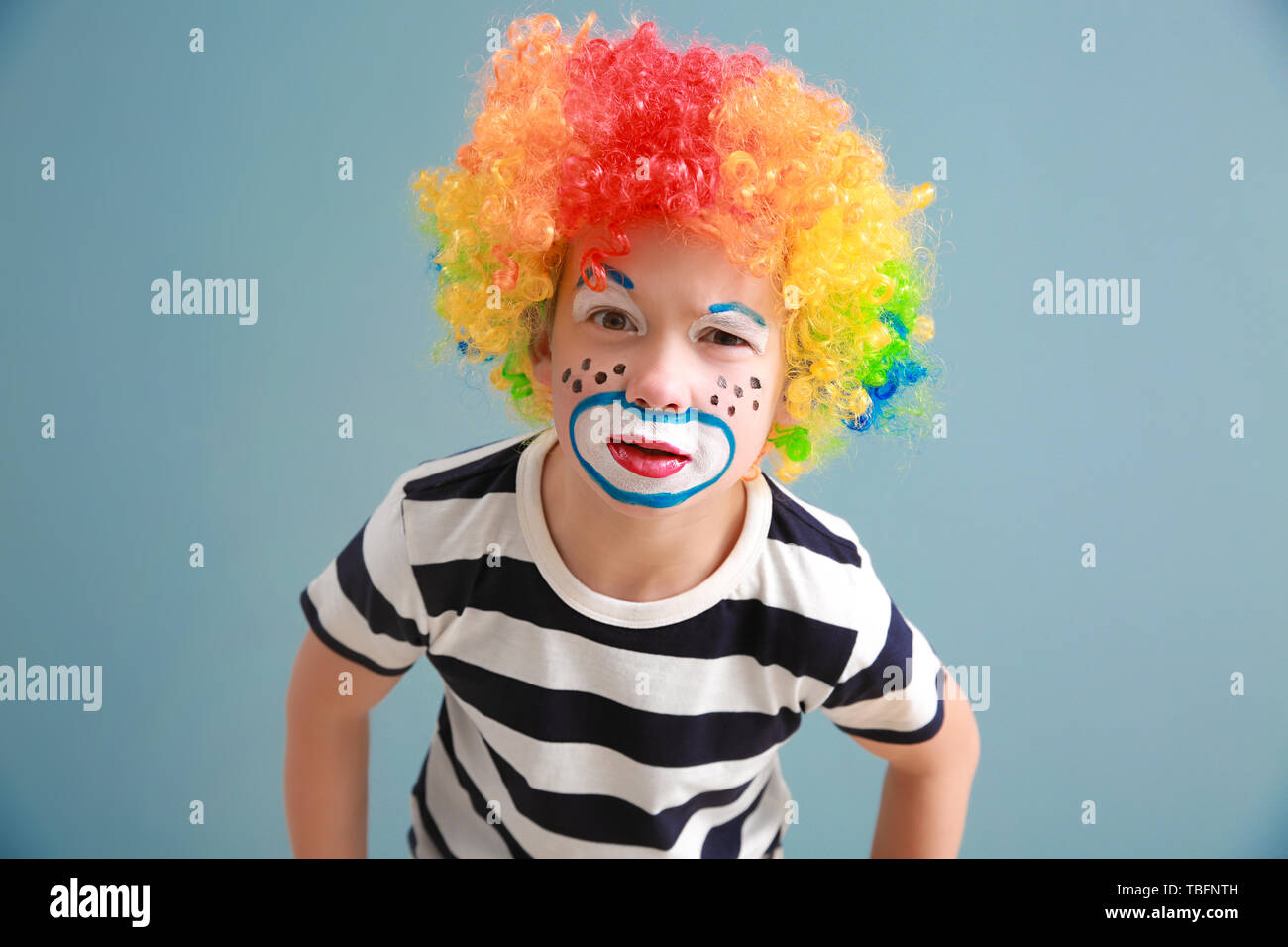 Cute little boy with clown makeup on color background. April fools' day ...