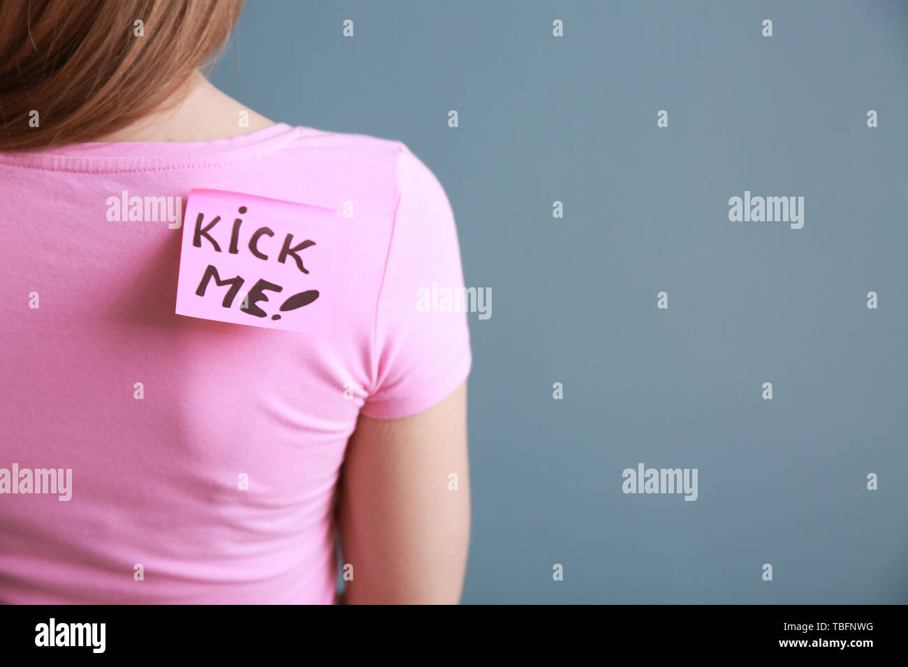 Sticky note with text "Kick me" on woman's back. April fools' day prank ...