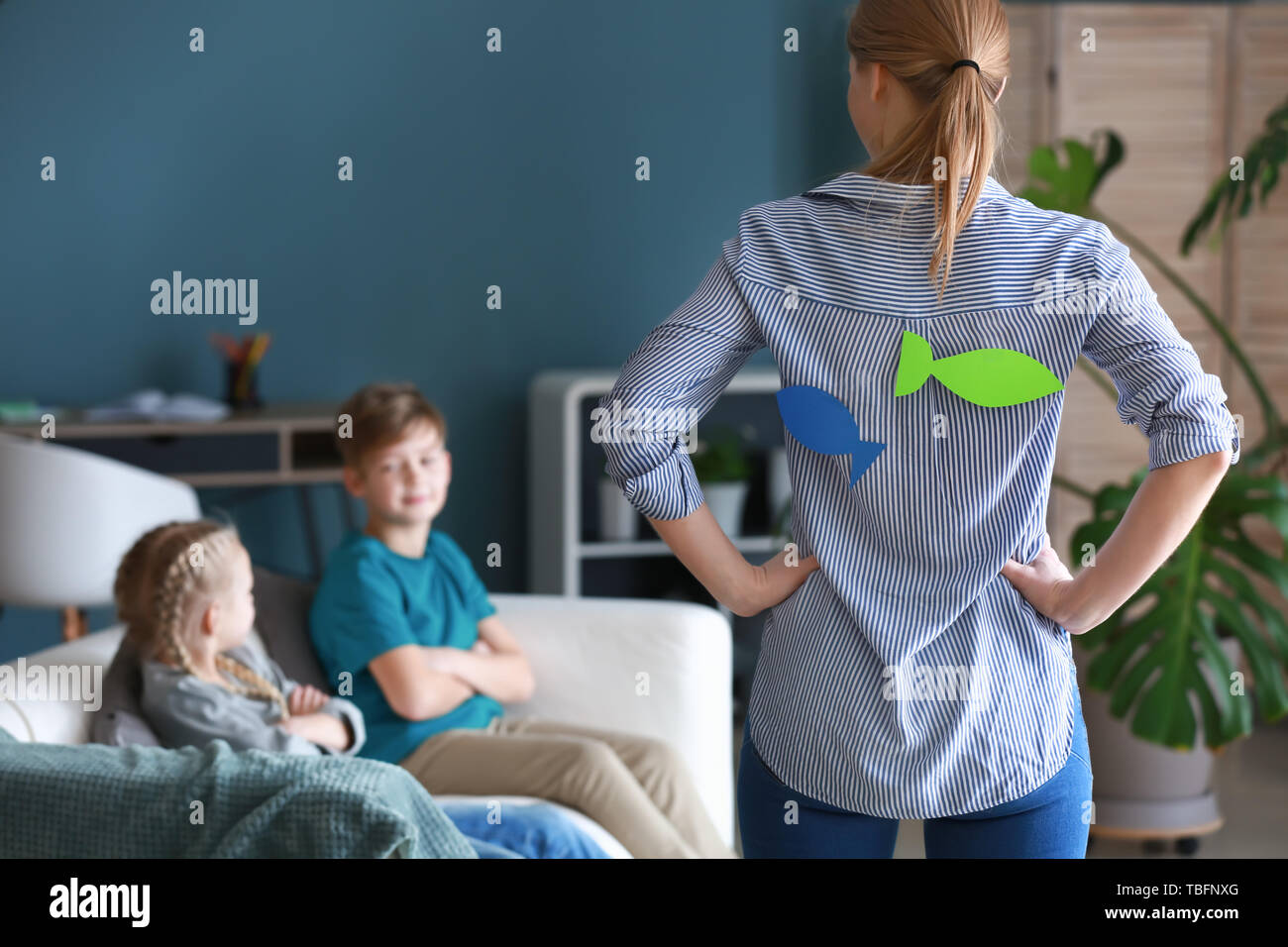 Mother with paper fish on her back scolding children. April fools' day ...