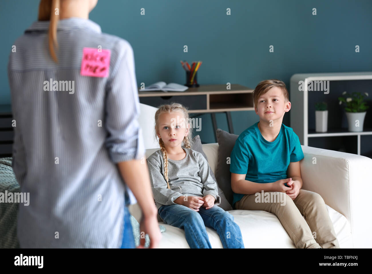 Woman and children who attached paper sheets with text KICK ME to her ...