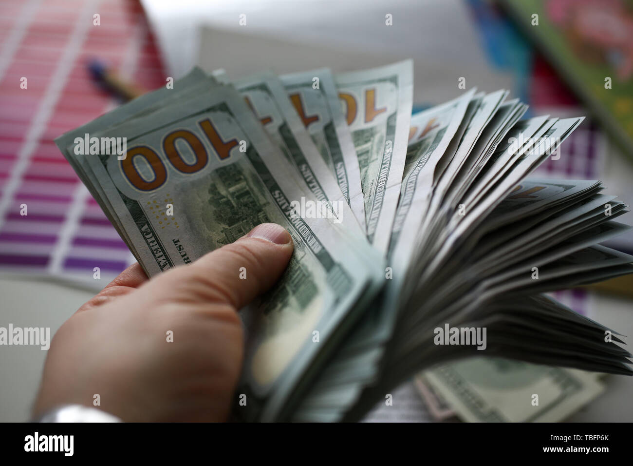 Man hold in hand big fat pack of US money Stock Photo - Alamy
