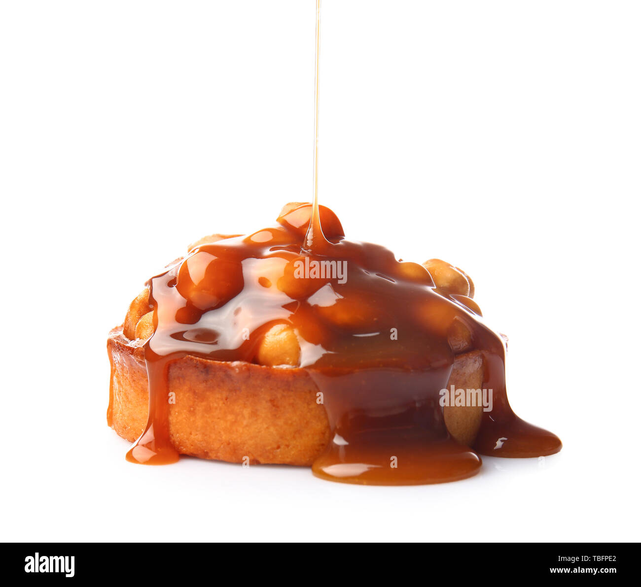 Liquid caramel pouring on cake against white background Stock Photo - Alamy