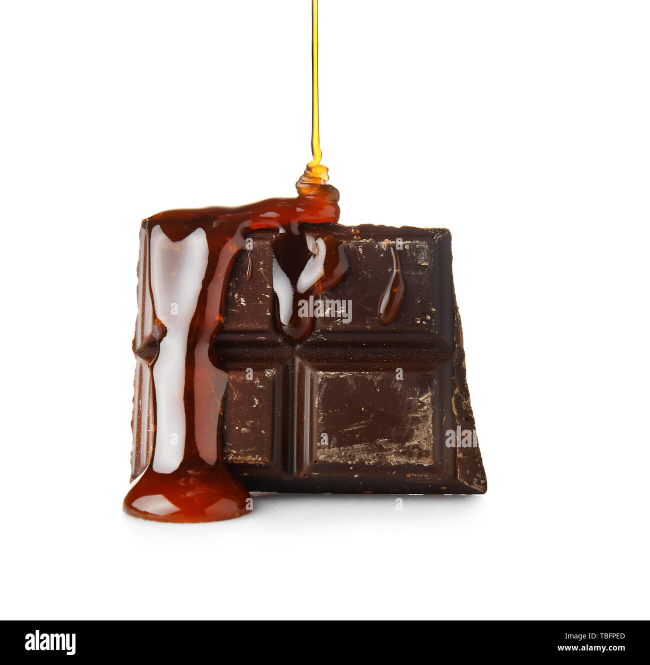 Liquid caramel pouring on chocolate against white background Stock ...
