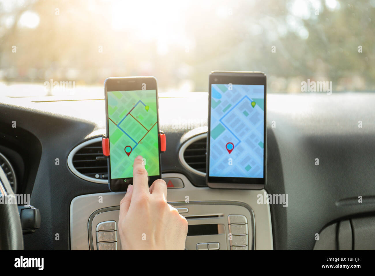 Car driver using mobile phones for navigation Stock Photo - Alamy