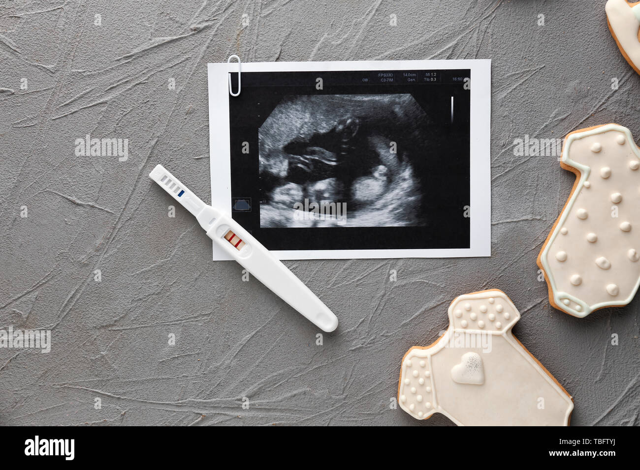 Pregnancy test, sonogram image and cookies on grey background Stock ...