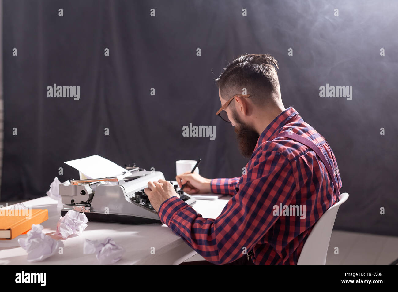 Writer's day and technology concept - Handsome writer surrounded by ...