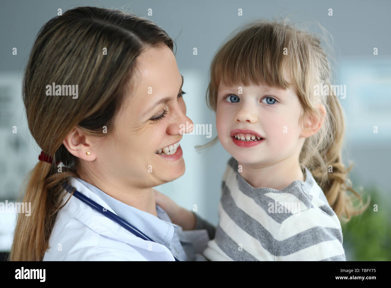 Paediatric doctor holding and hugging little cute girl patient Stock ...