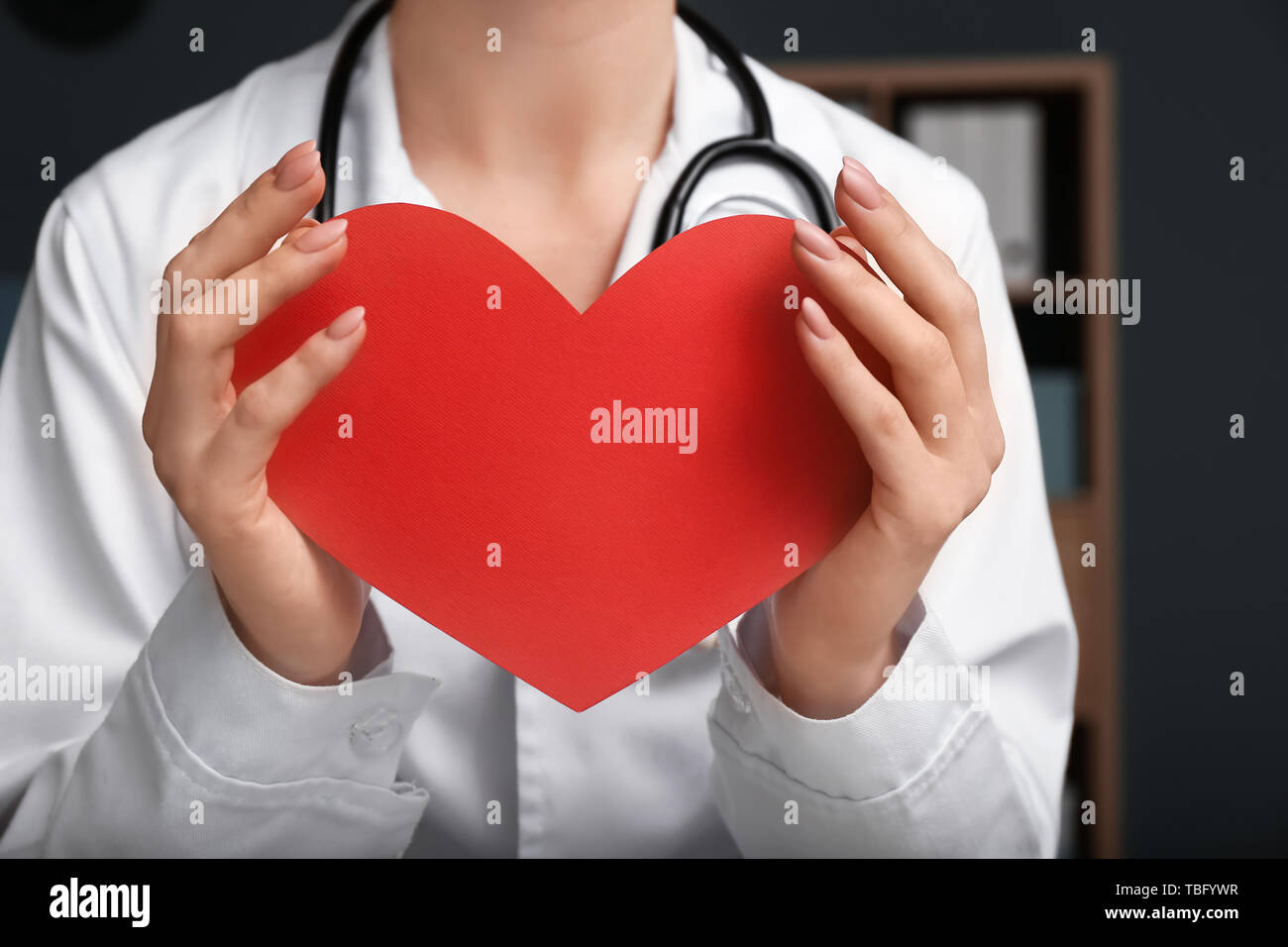 Cardiologist with red heart in clinic, closeup Stock Photo - Alamy