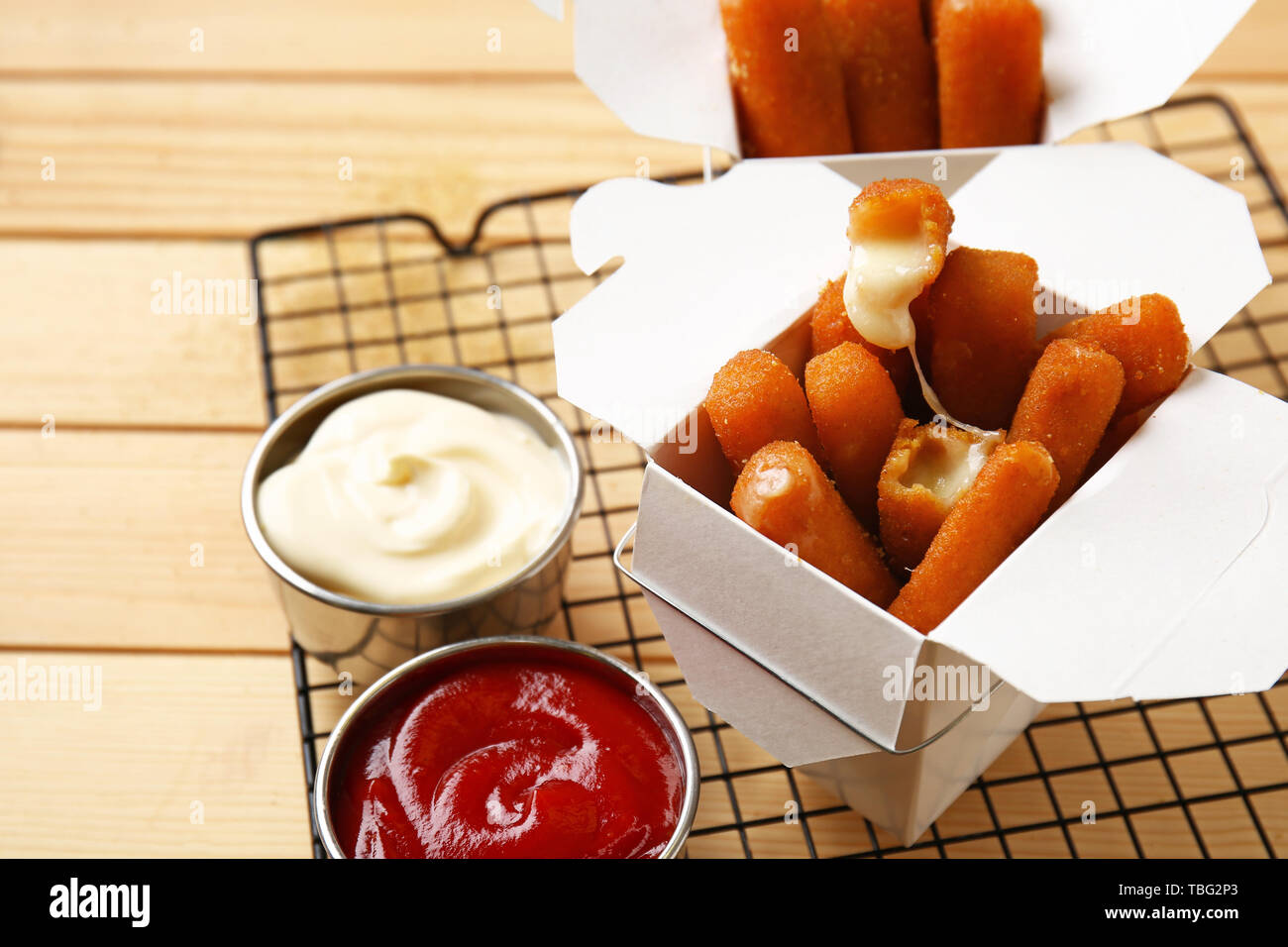Box with tasty mozzarella sticks and sauces on wooden table Stock Photo ...