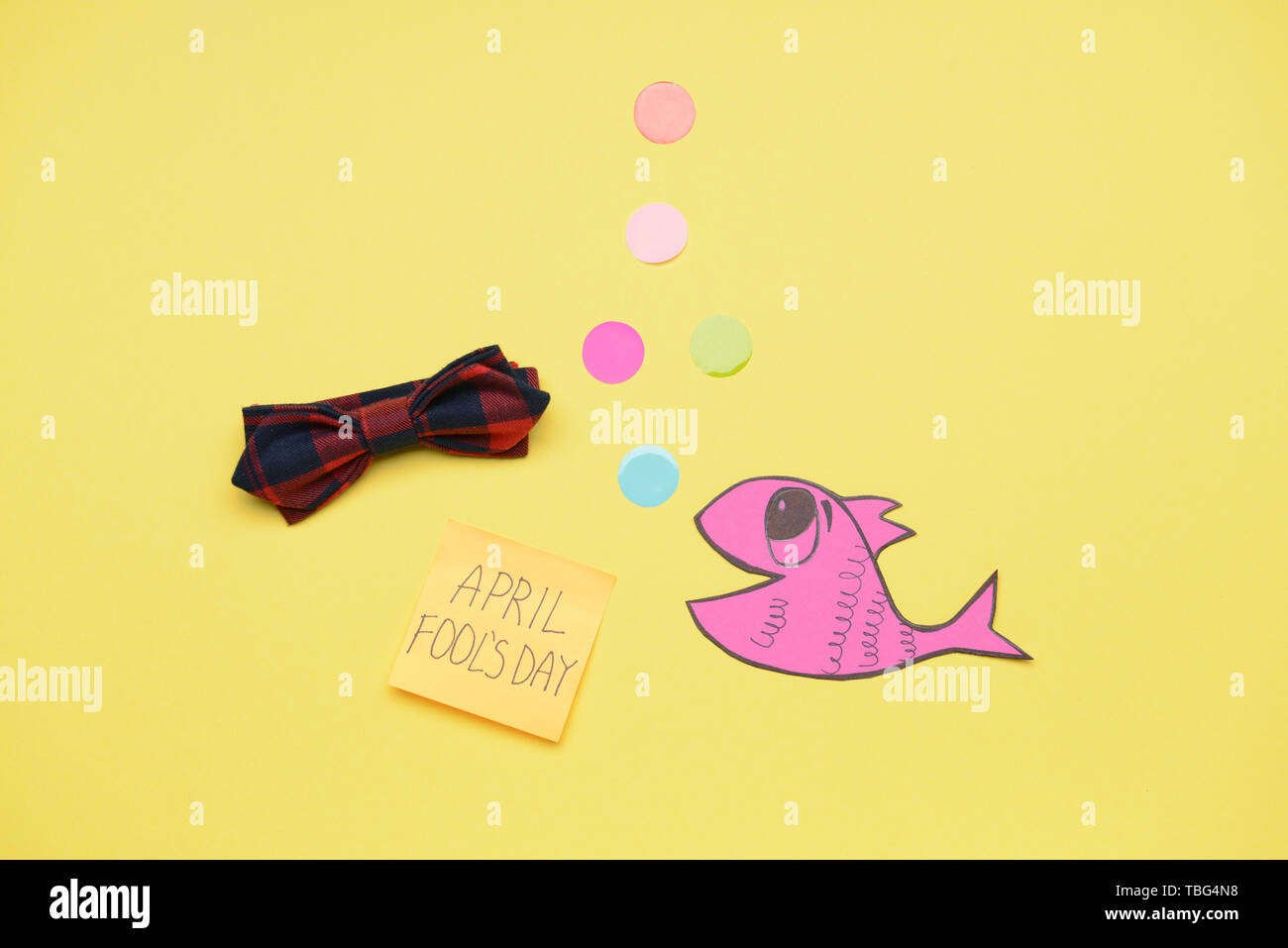 Bow tie, paper fish and sticky note with text APRIL FOOL'S DAY on color ...