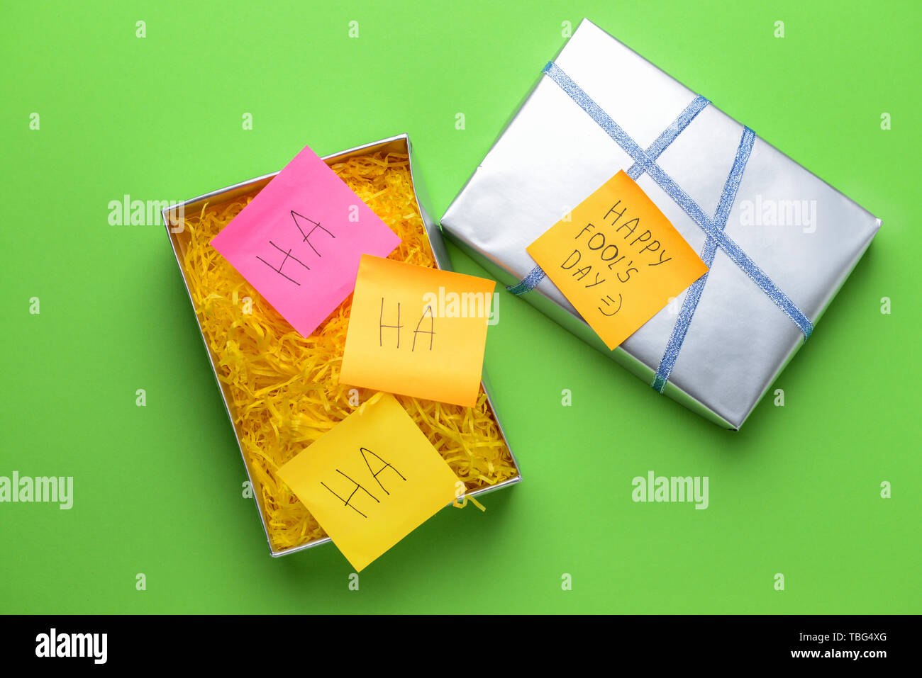 Box with sticky notes on color background. April Fool's Day prank Stock ...