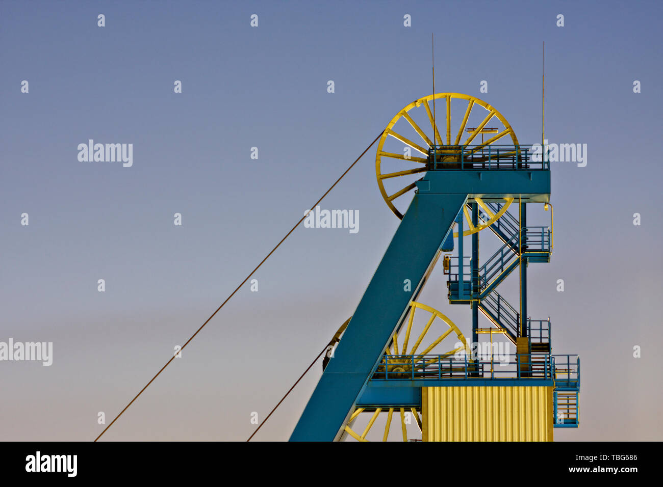 Shaft tower with wheels and ropes at dusk Stock Photo - Alamy