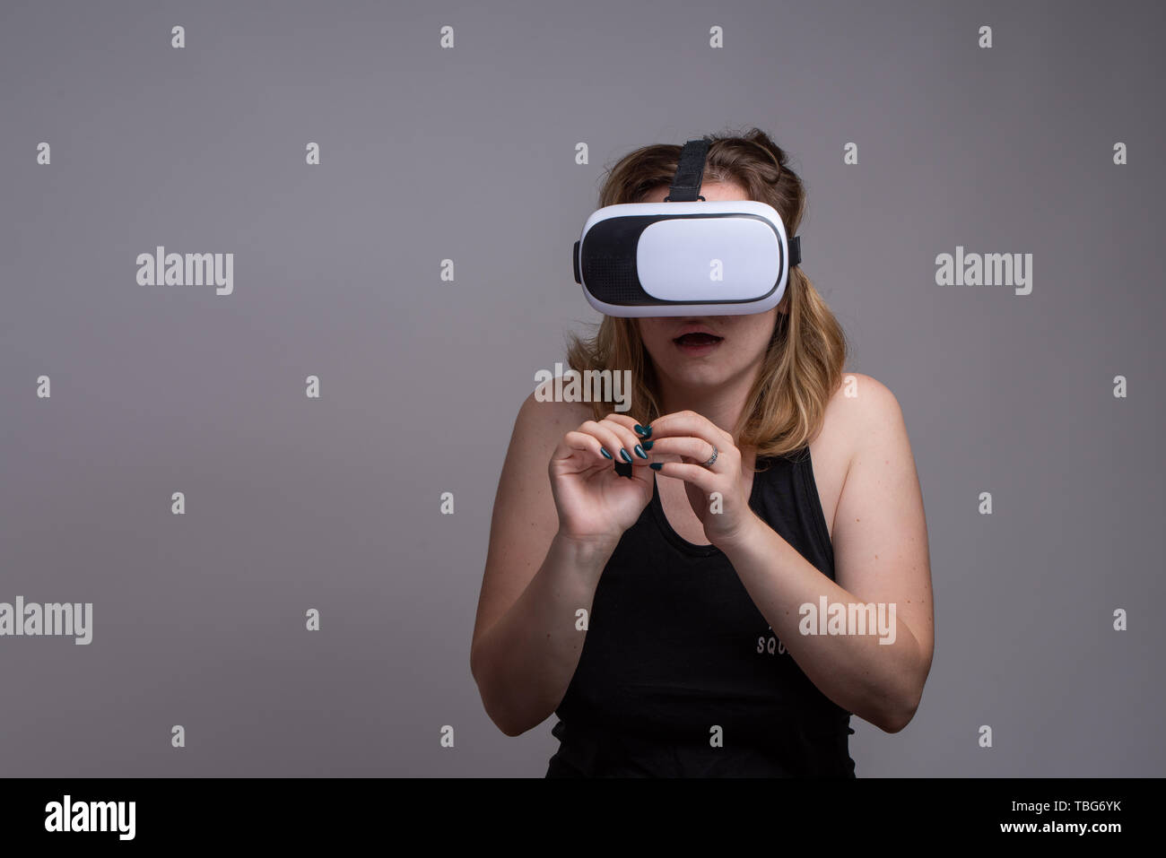 Woman being afraid while experiencing virtual reality using a VR gadget ...