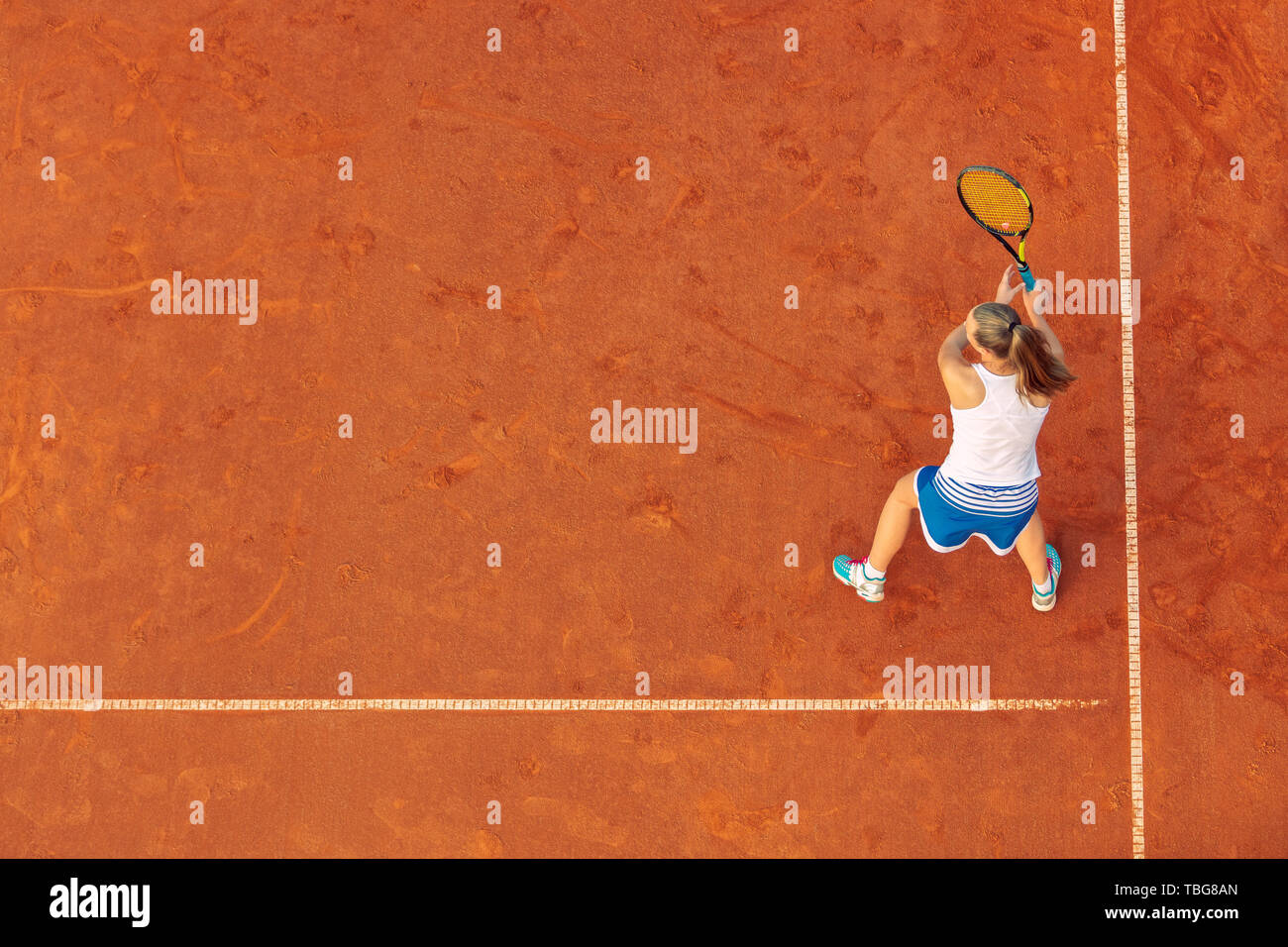 Aerial shot of a female tennis player on a court during match. Young ...