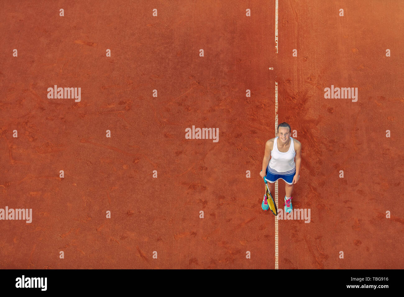 Aerial shot of a female tennis player on a court during match. Young ...