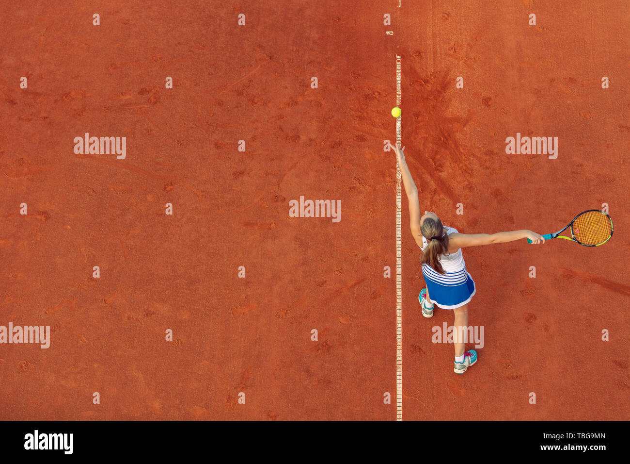 Aerial shot of a female tennis player on a court during match. Young ...