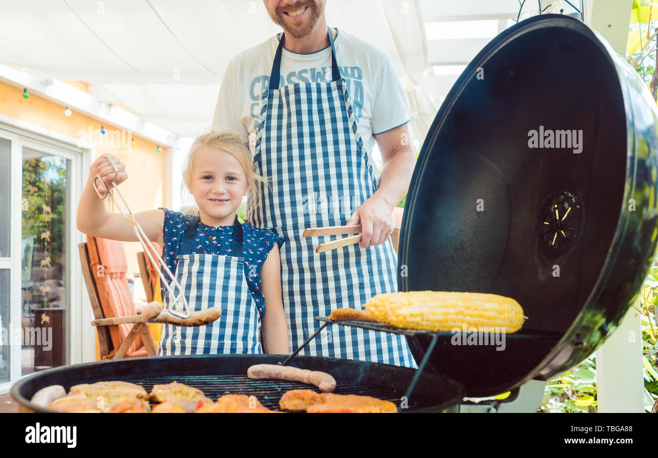 Dad and kid doing the barbeque at the grill Stock Photo - Alamy