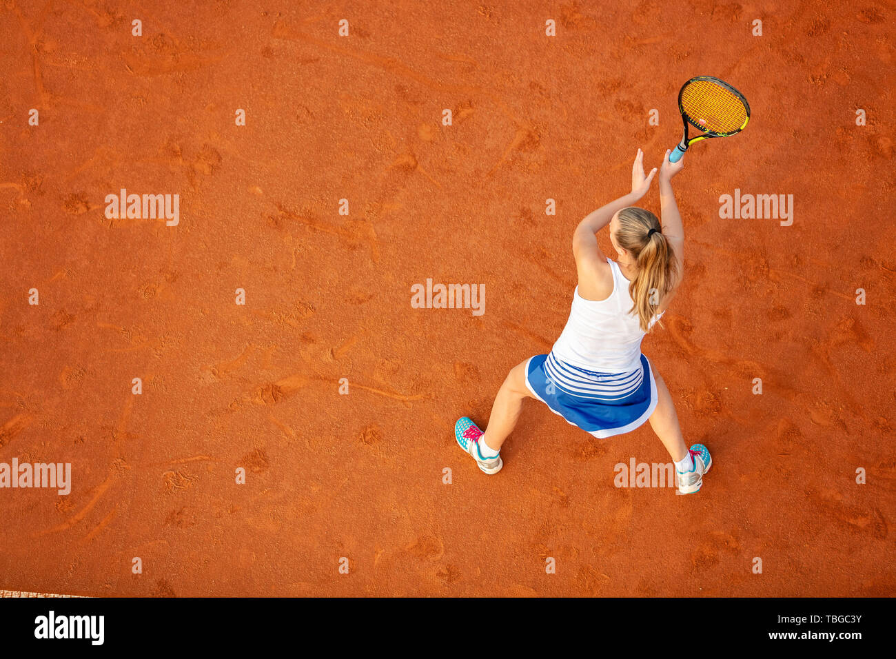 Aerial shot of a female tennis player on a court during match. Young ...