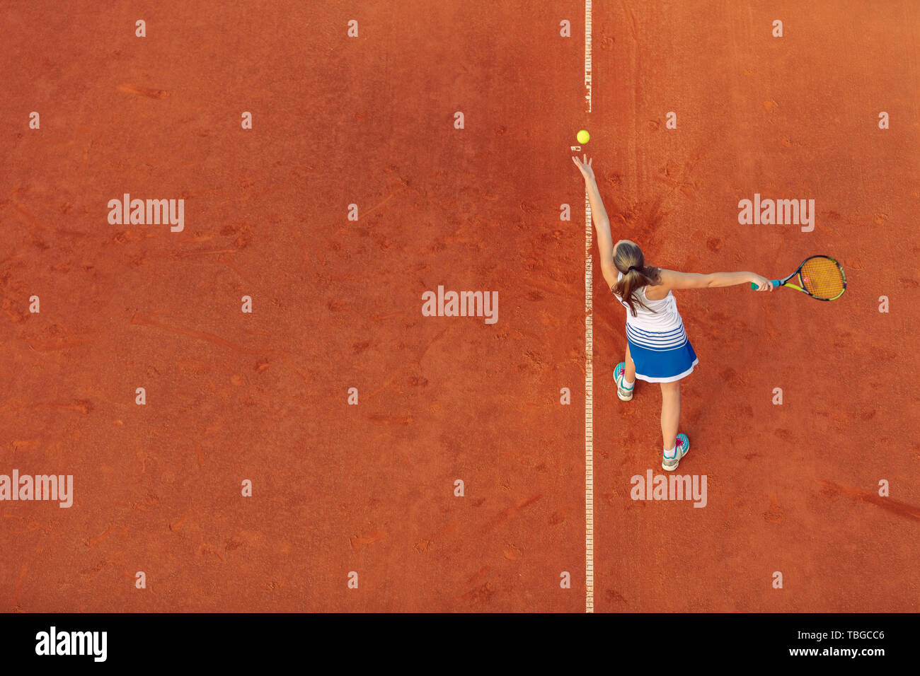 Aerial shot of a female tennis player on a court during match. Young ...