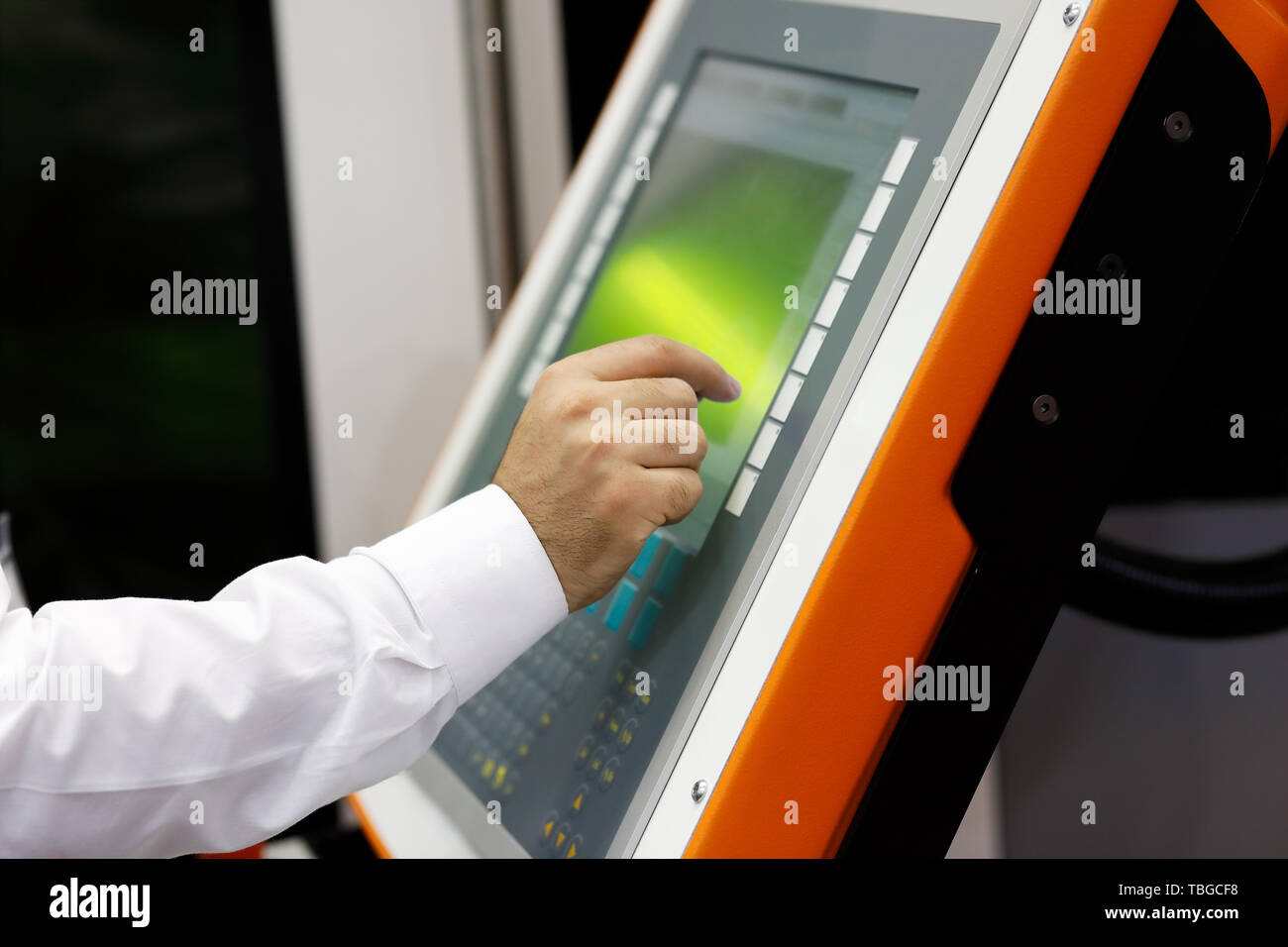Engineer working with touch screen on the control panel of CNC laser ...