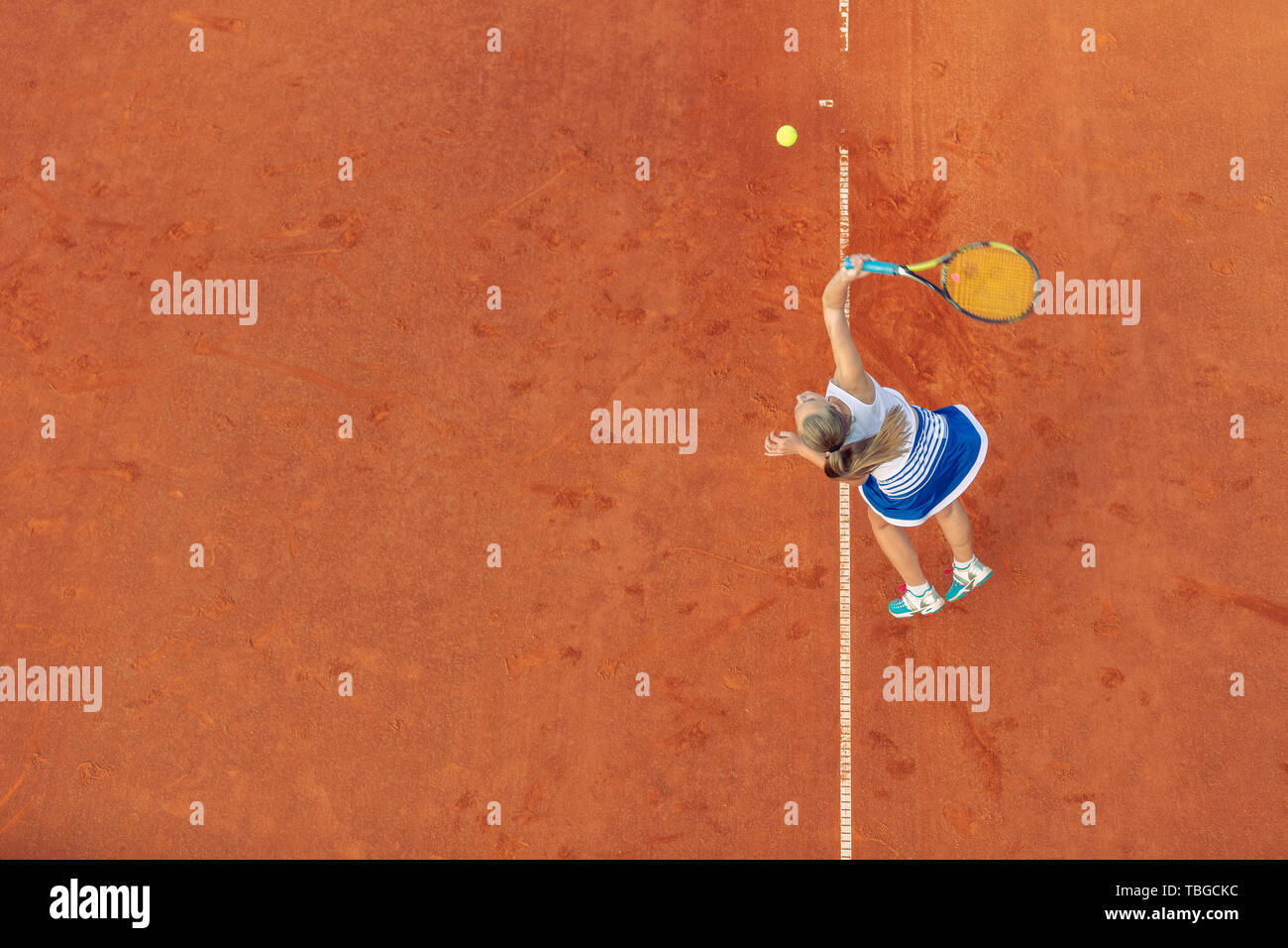 Aerial shot of a female tennis player on a court during match. Young ...