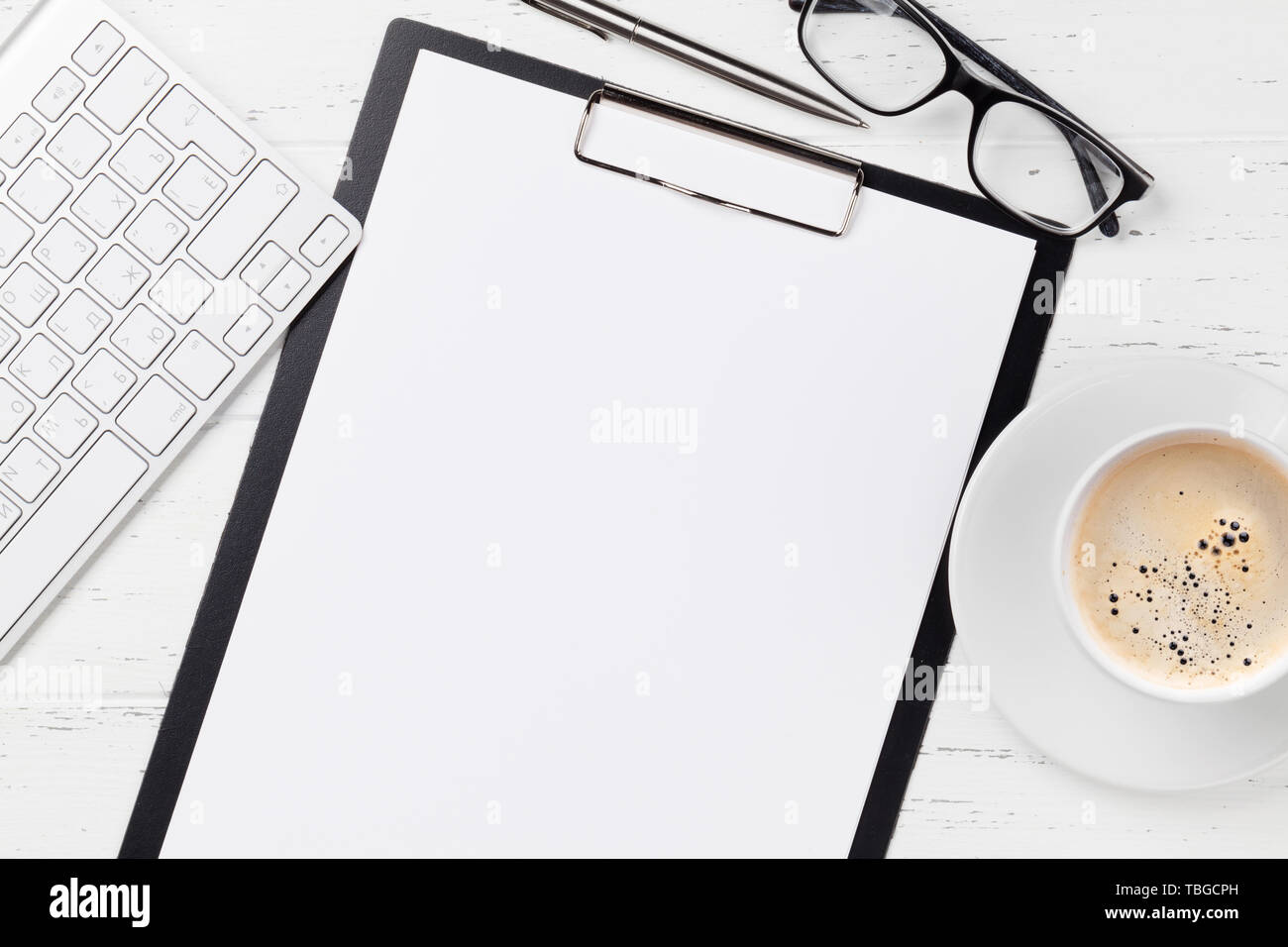 Office workplace table with blank paper page, coffee cup, supplies and ...
