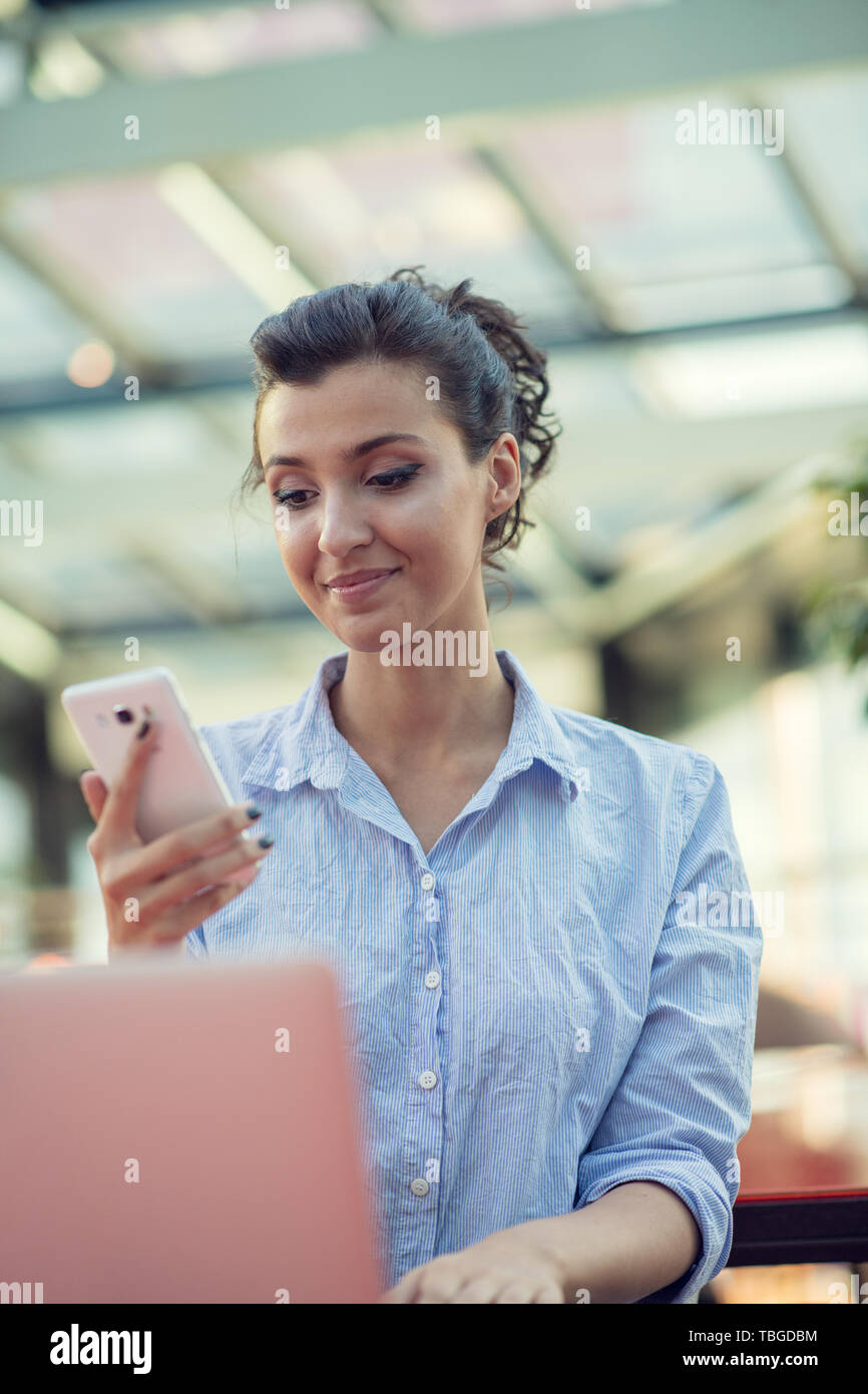 Portrait of a playful young girl taking selfie with mobile phone while ...
